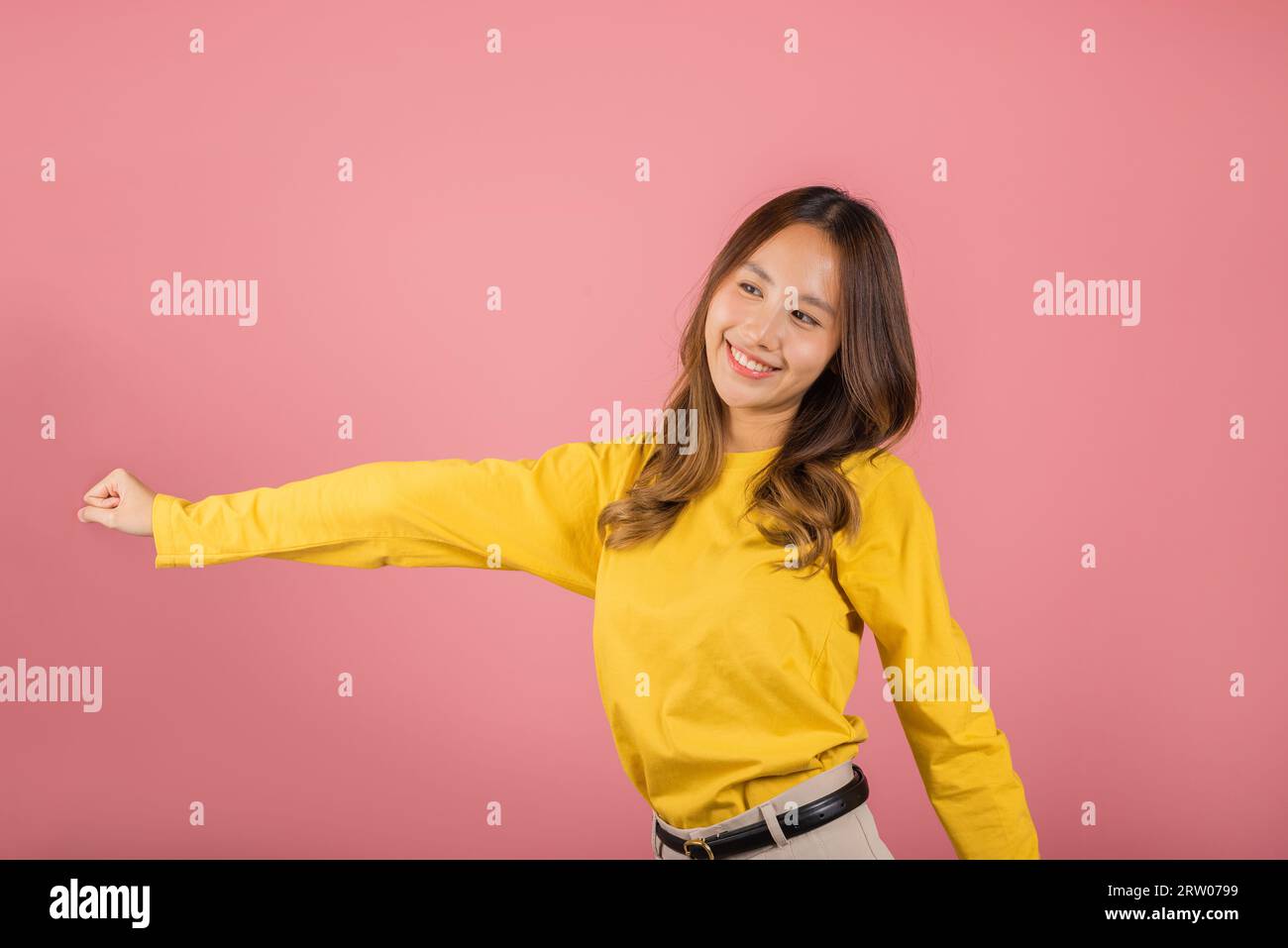 Asian young woman dancing with inspired face expression and raising ...