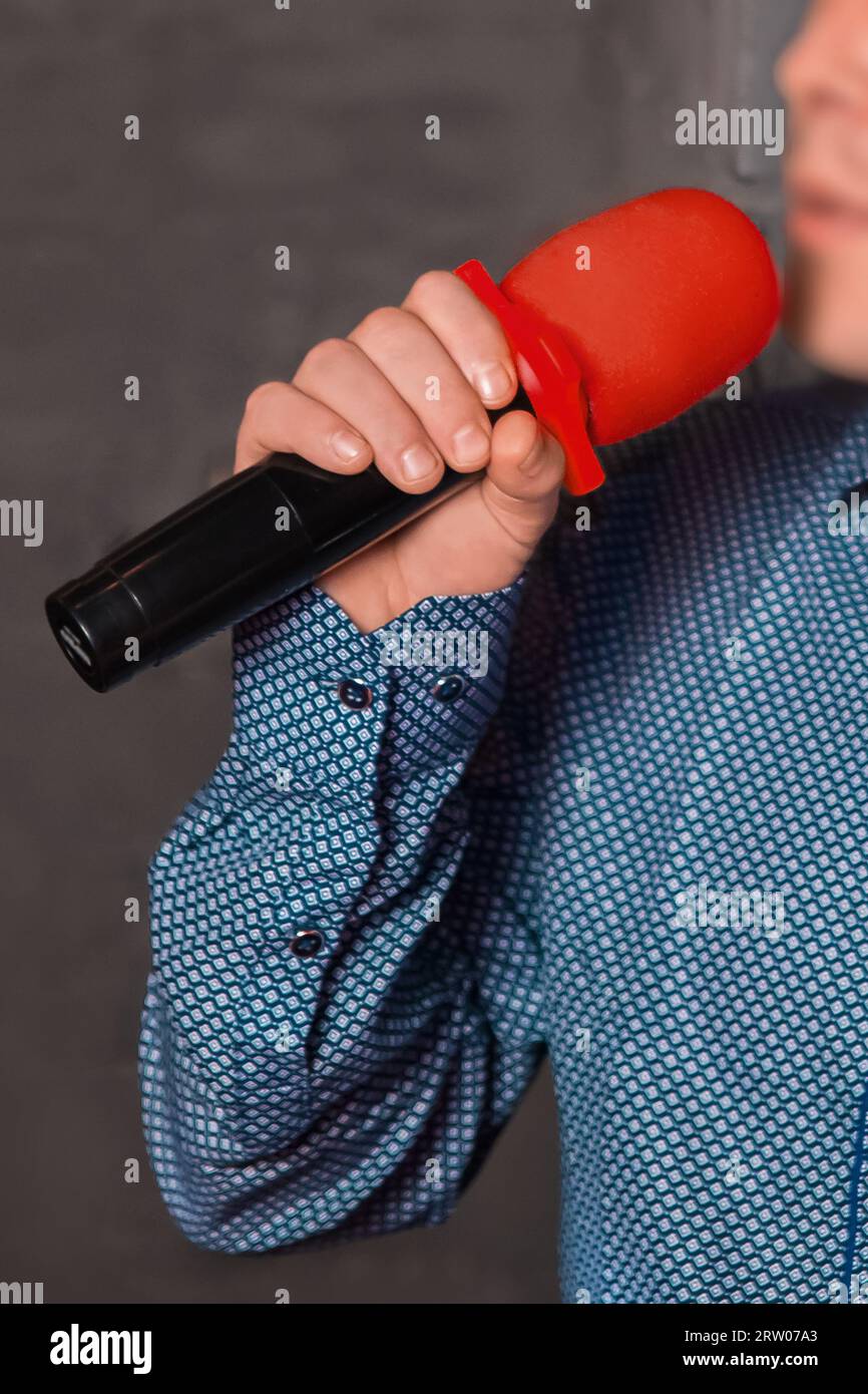 The person's hand holds a microphone, a professional karaoke singing ...