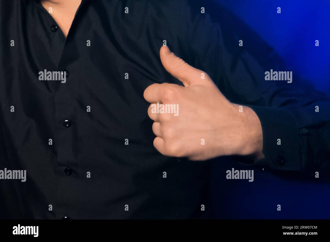 Person hand shows class cool thumb top close-up on dark background ...