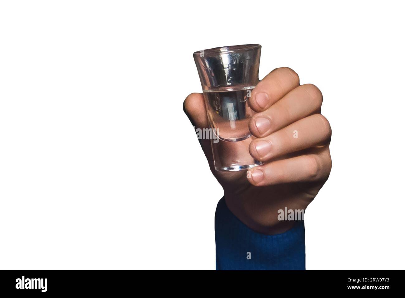 A man's hand close-up holds a glass of alcohol-cooled vodka on a white ...