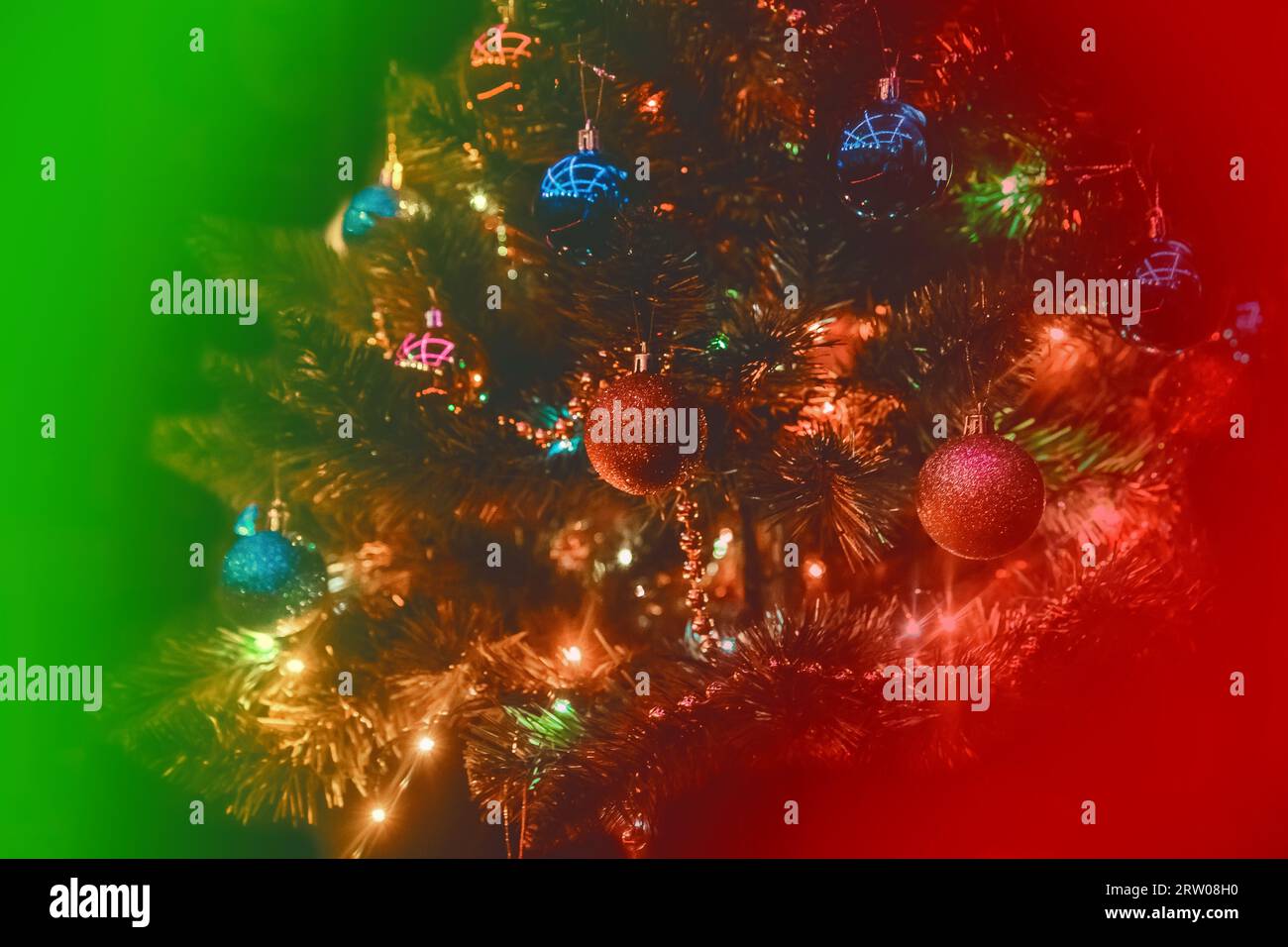 New Year's decorated mini spruce with balls and lights in red and green ...