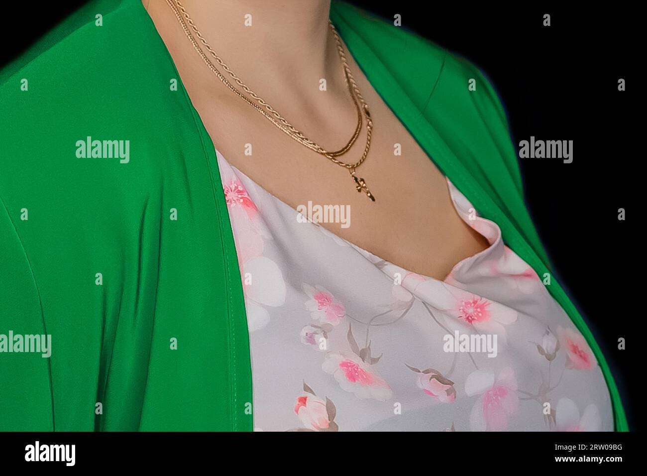 Person in a green thin cape and a light blouse with a pattern of ...