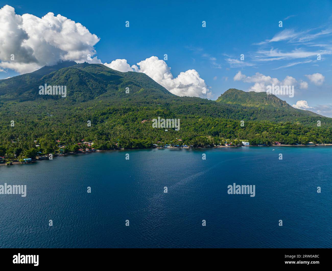 Tropical island with houses on coastline and blue sea of Camiguin ...