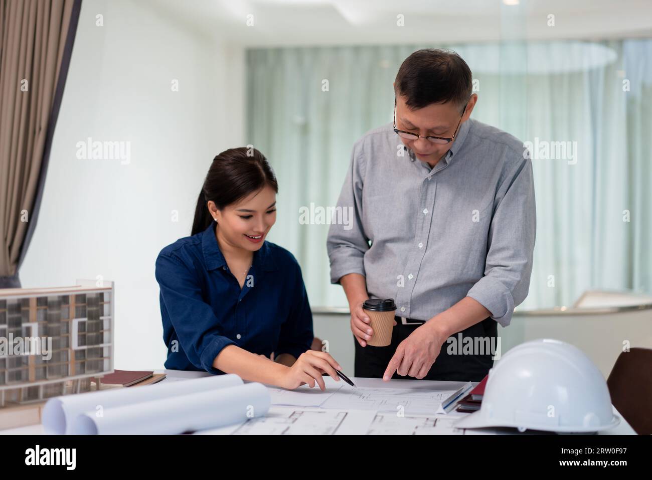 Two architects pointing on blueprint to analysis and planning about ...