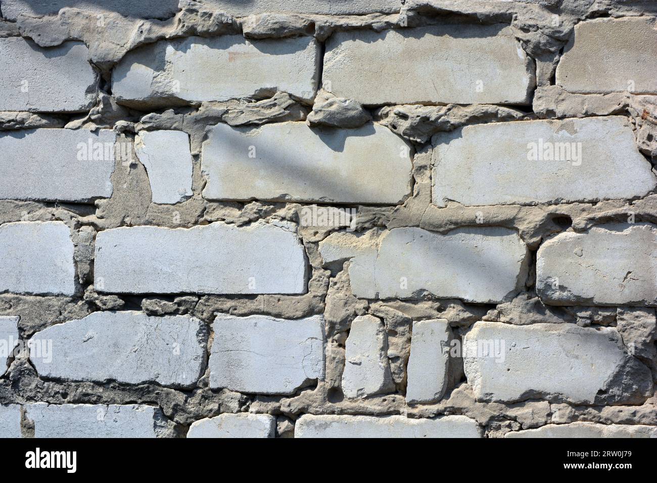 Unusual construction background, white bricks smeared with gray cement ...