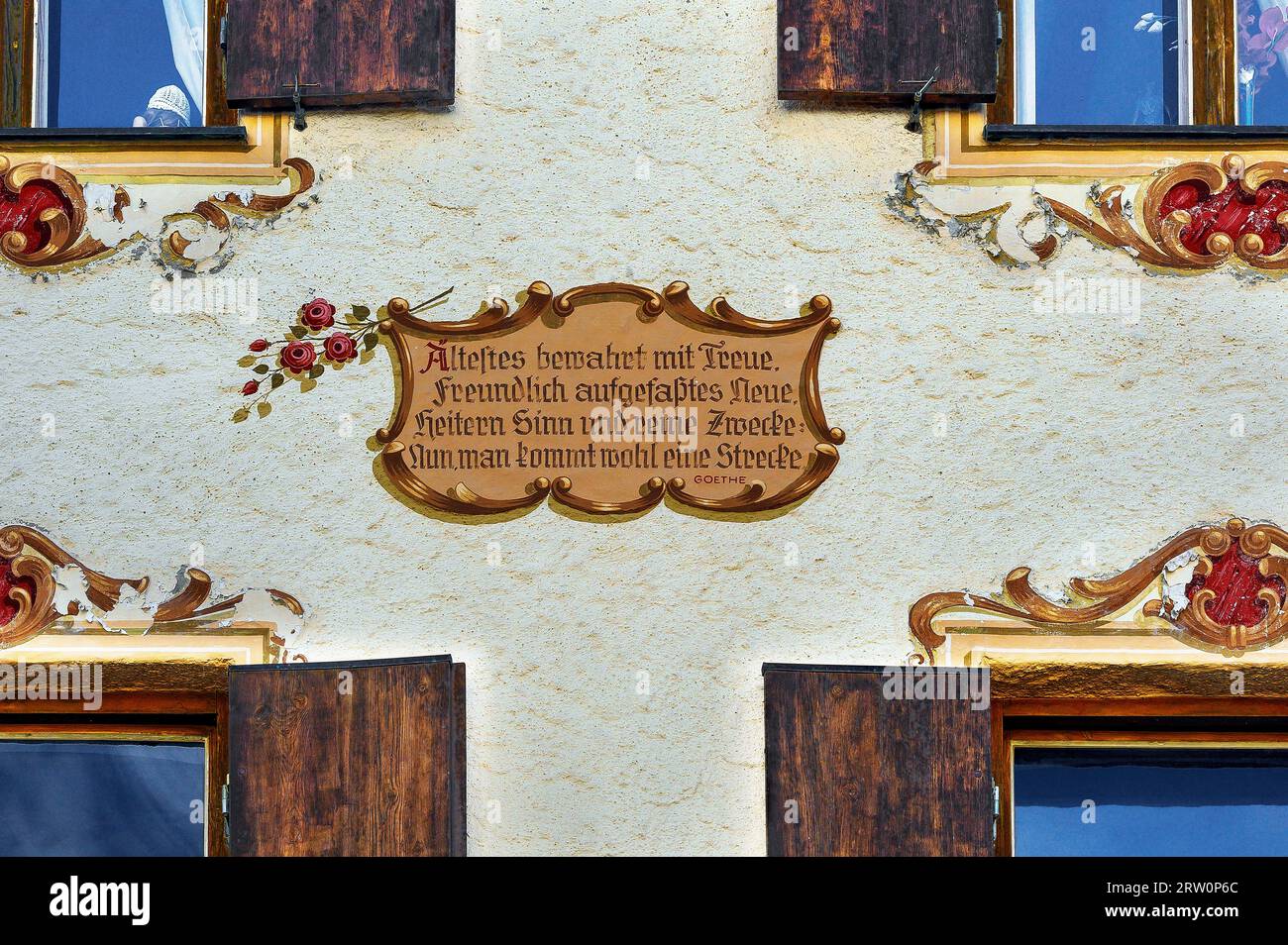 Restored old building facade with painted window decorations and motto ...