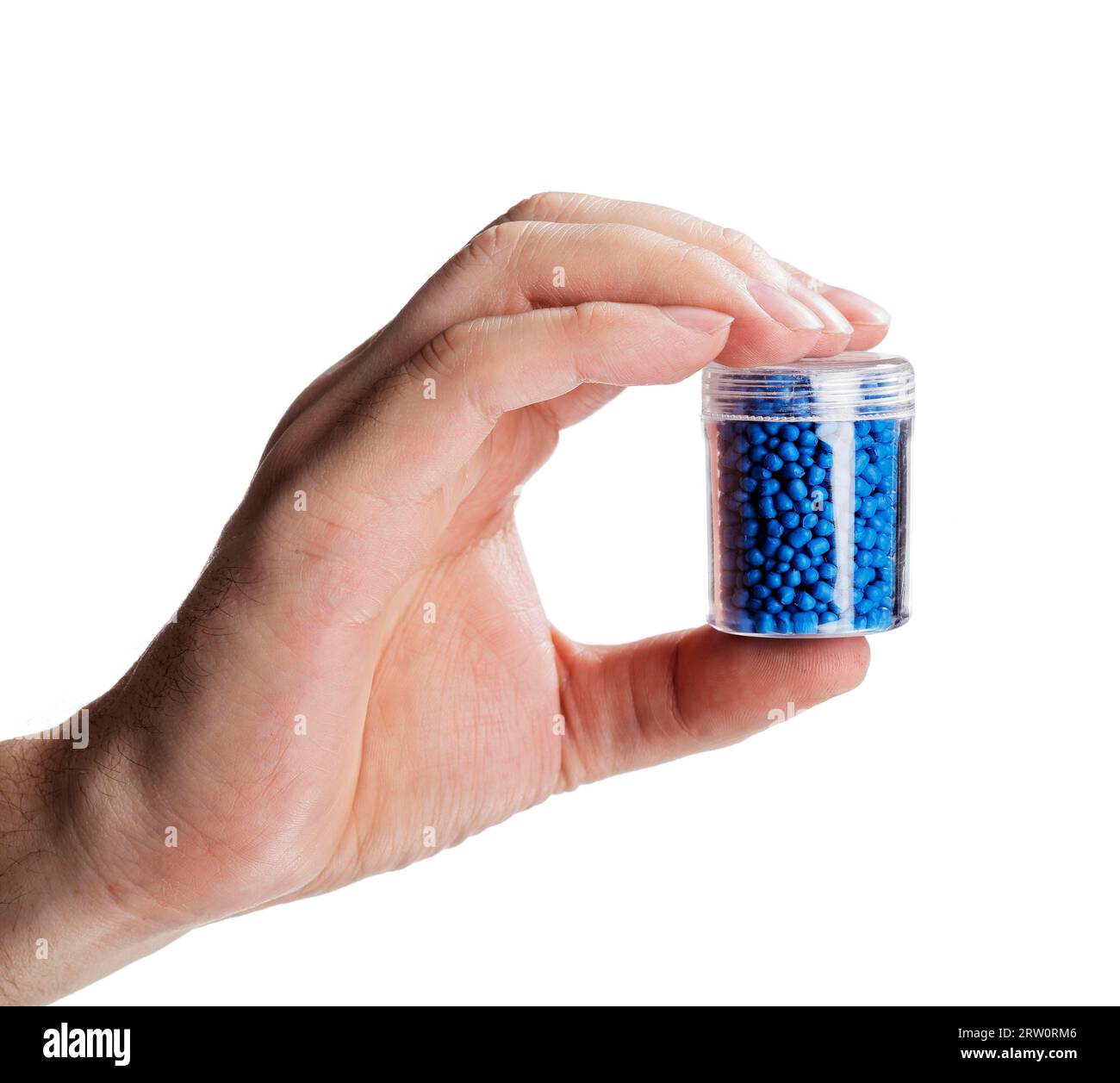 Man holding a small container with blue plastic granules, used for ...