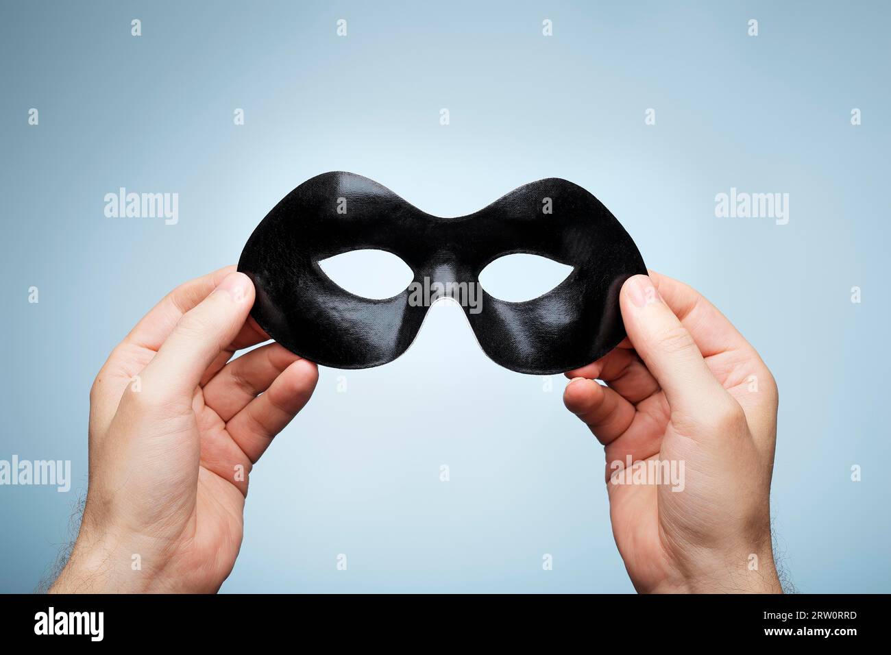 Man holding a black eye mask in his hands Stock Photo - Alamy