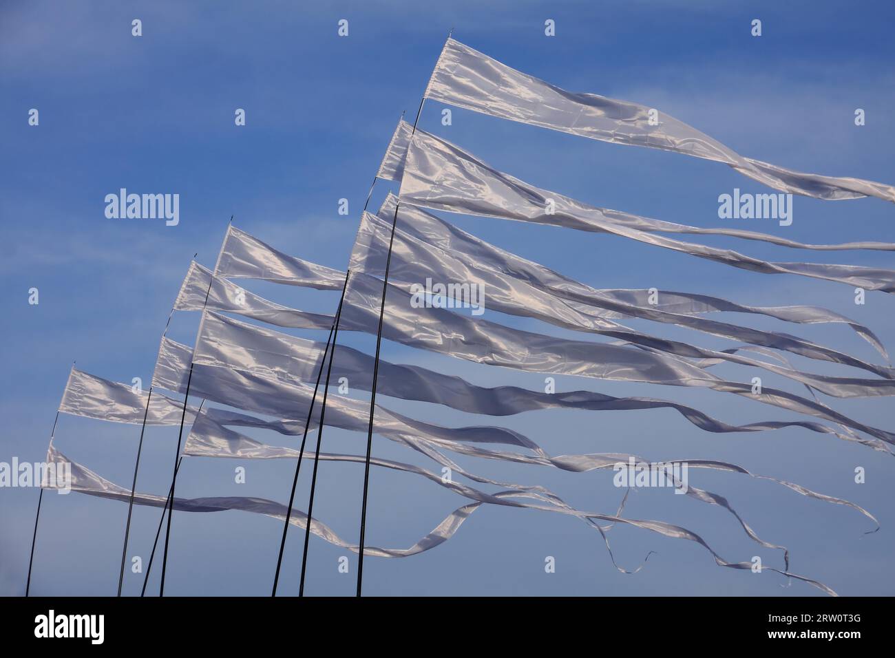 Silver waving flags, blue sky background Stock Photo - Alamy