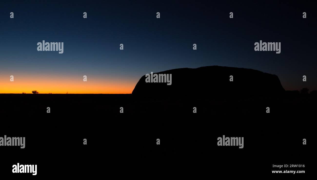 Majestic Uluru at sunrise on a clear winter's morning in the Northern ...