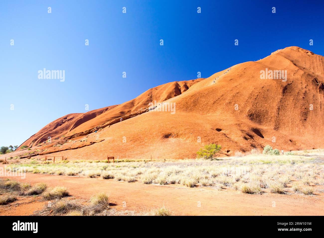 Uluru, Australia, July 4, 2015: Climbers ascend Uluru against the ...