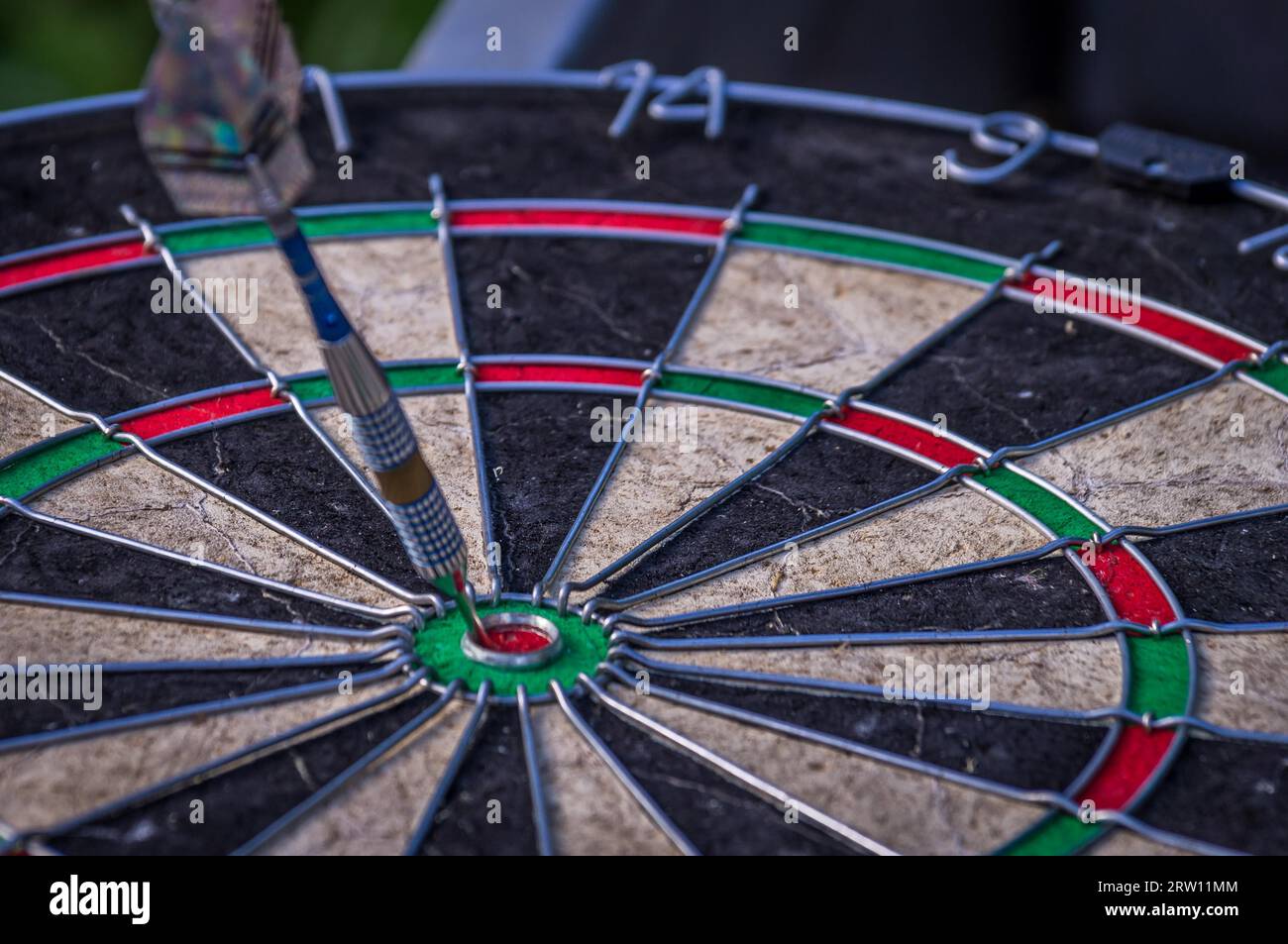 Dart arrow hitting in the target center of dartboard illustrates the ...