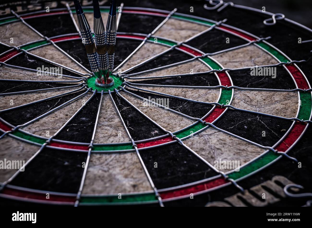 Three dart arrows hitting in the target center of dartboard ...