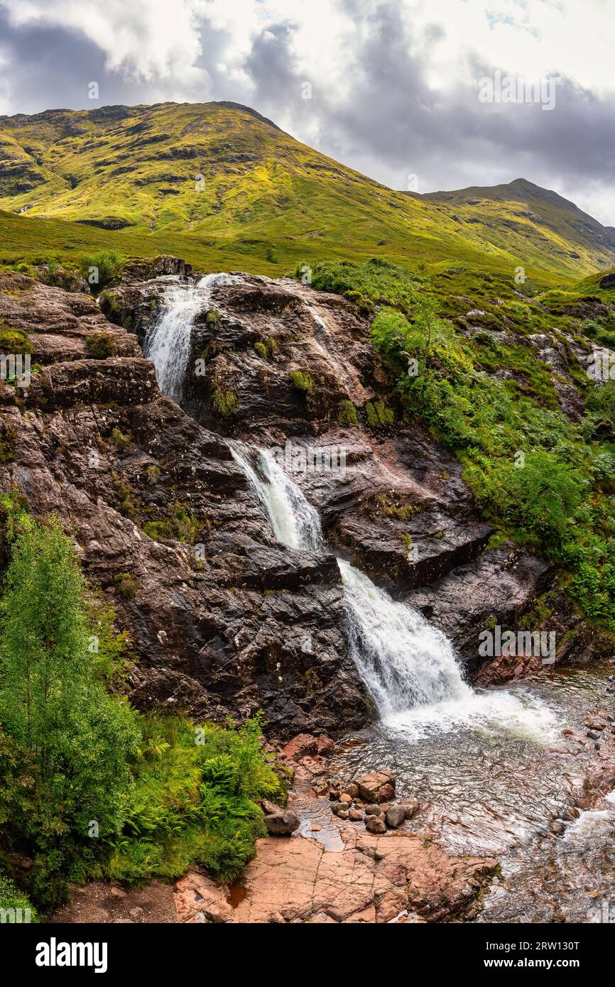Stunning scenery with high mountains and three waterfalls converging in ...