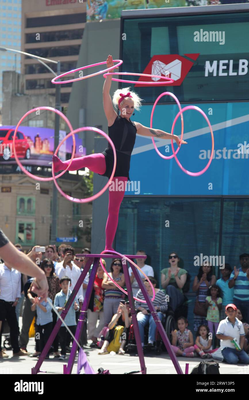 Acrobat performs a hula-hoop in Federation Square in Melbourne ...