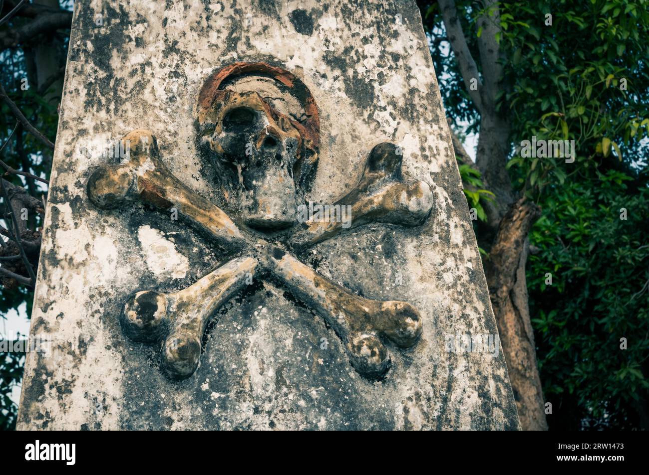 Photo of stone column with symbol of death, skull and bones in cemetery ...