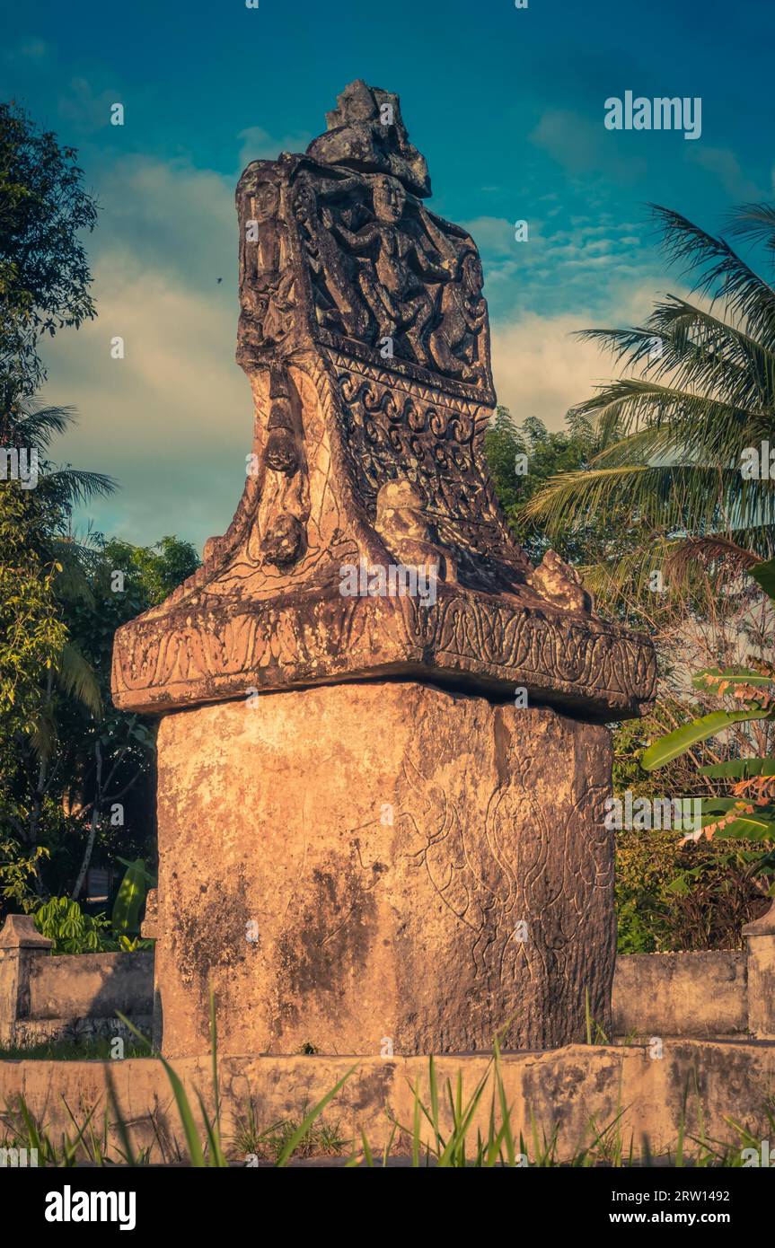 Photo of high stone monument with carvings in cemetery in Waruga in ...