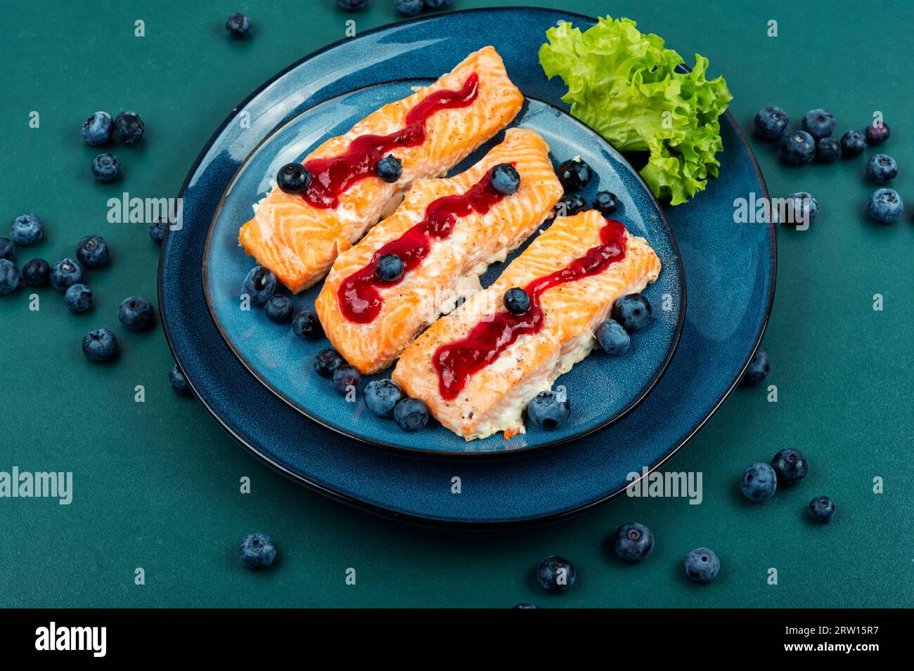 Baked salmon fish fillet with blueberry berry sauce on ceramic plate ...
