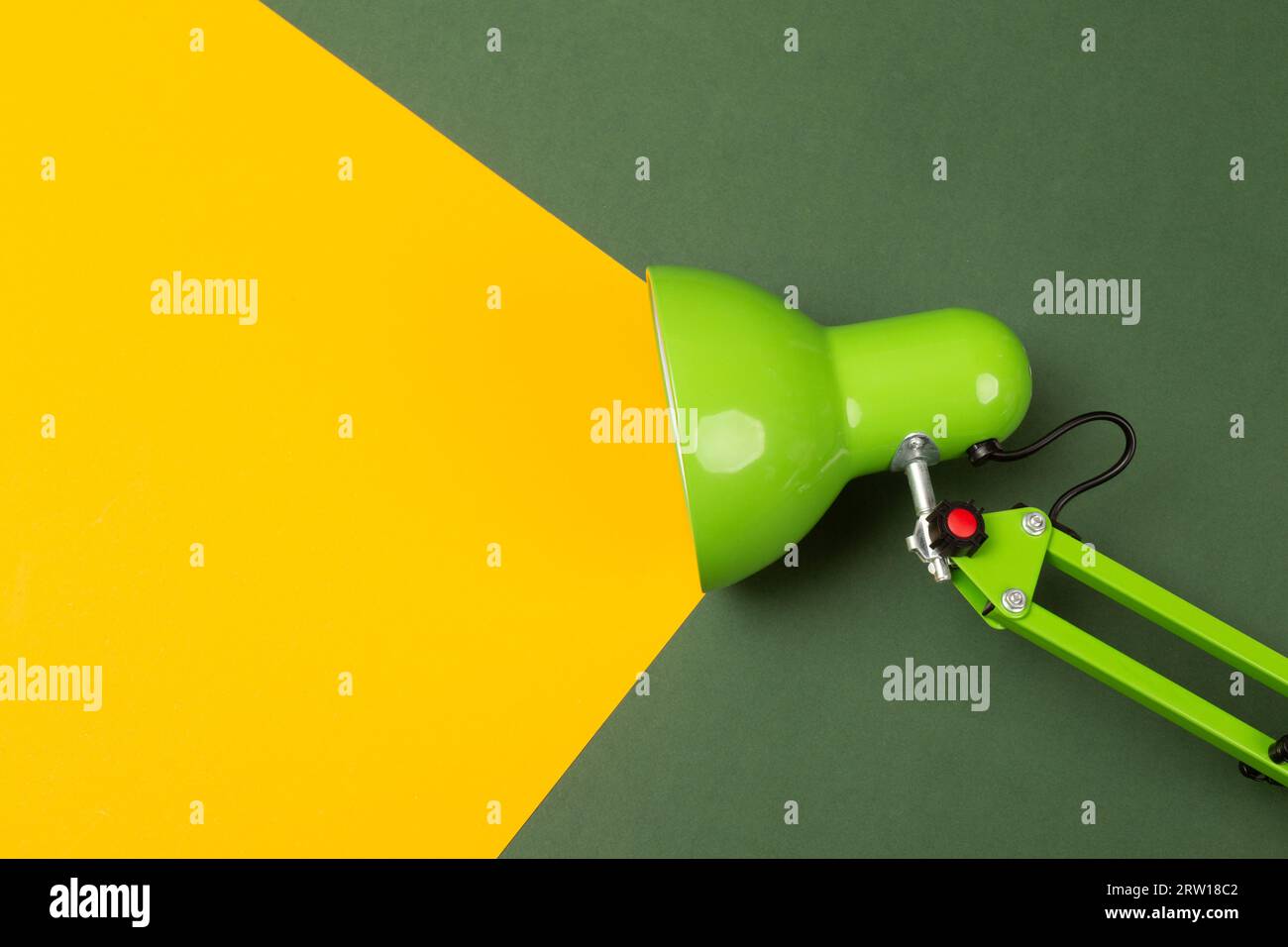 Table lamp with a beam of light directed at a small plant. The beam ...