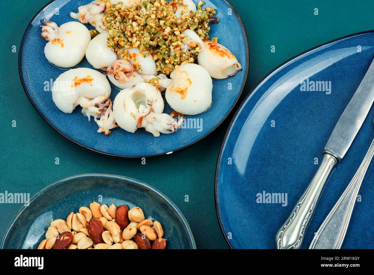 Baked young squids or calamari with nut garnish. Roasted whole calamari ...