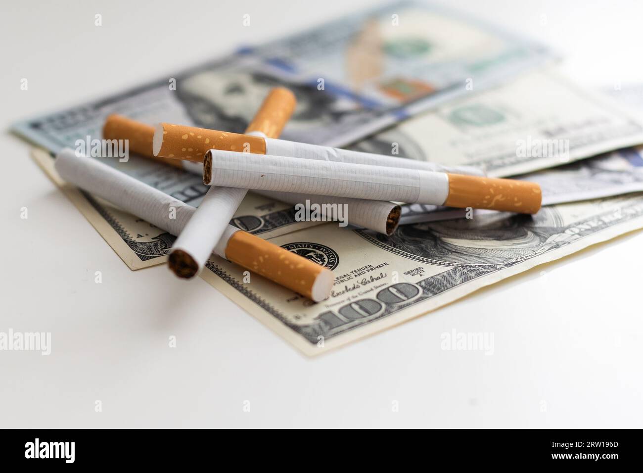 cigarettes and money. expensive habit. white background - horizontal ...