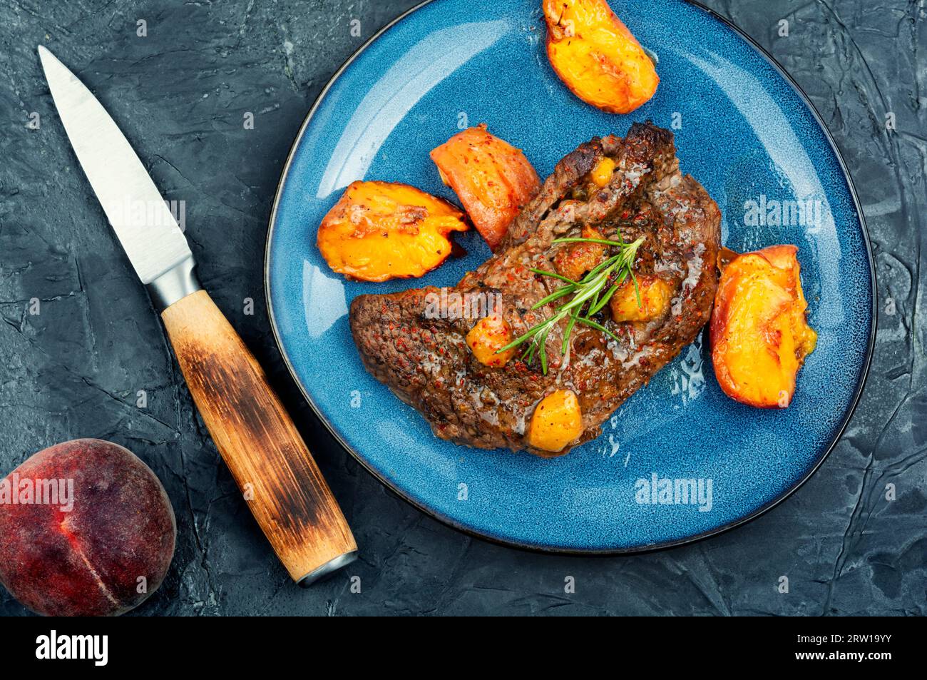 Tasty beef steak with peach in fruit marinade. Top view Stock Photo - Alamy