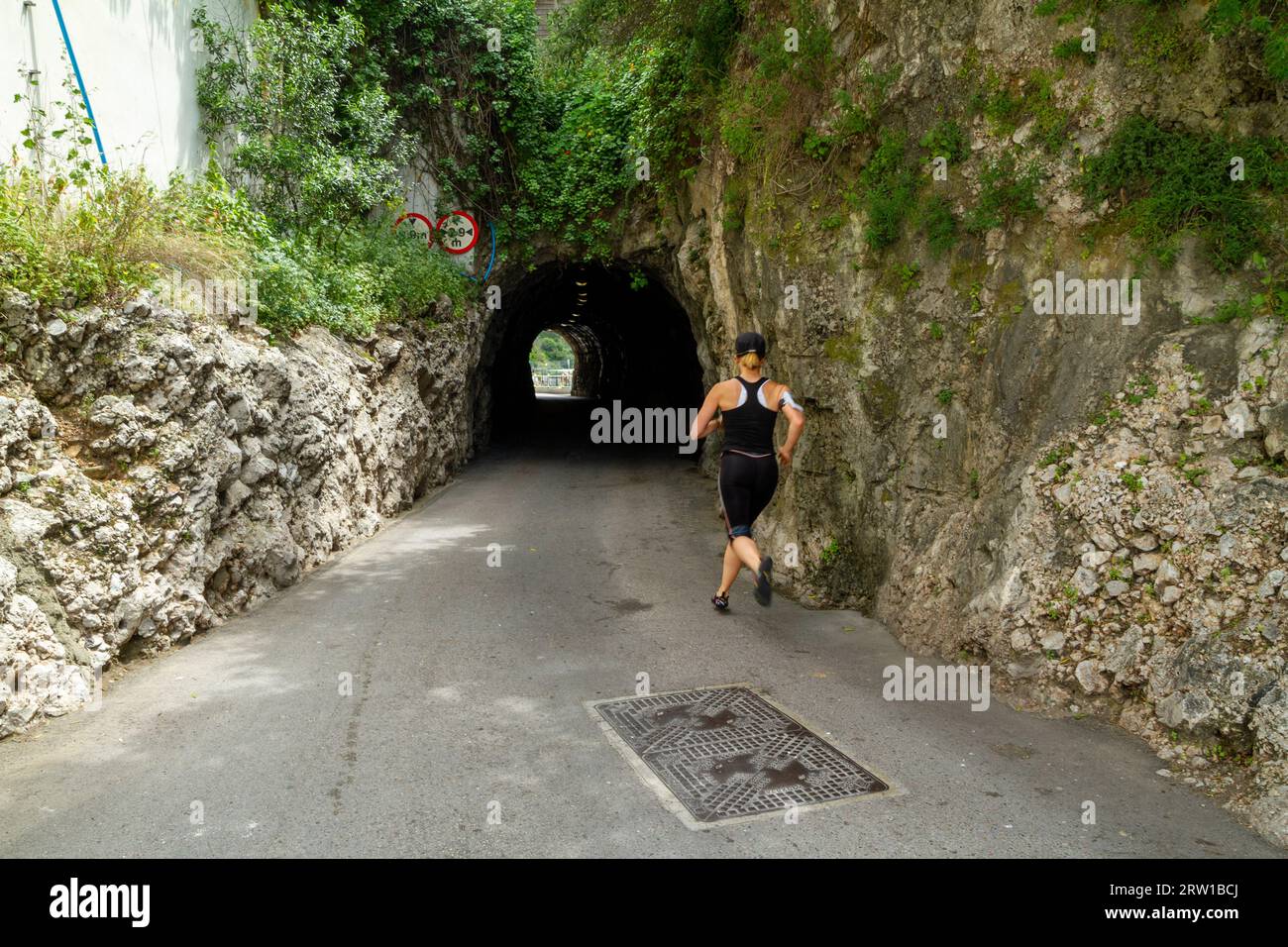 An athletic woman training by running through a tunnel on the Rock of ...