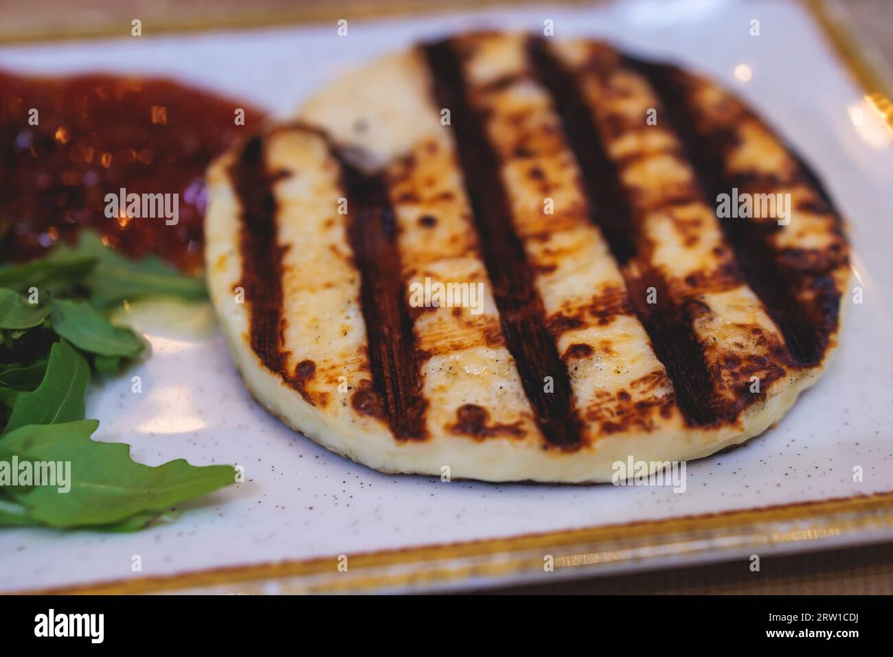 Fried halloumi cheese on a plate with sweet jam close up, traditional ...