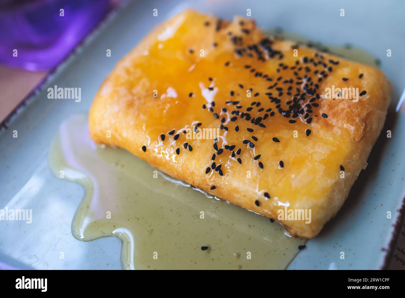 Fried feta cheese wrapped in phyllo pastry with honey and sesame ...