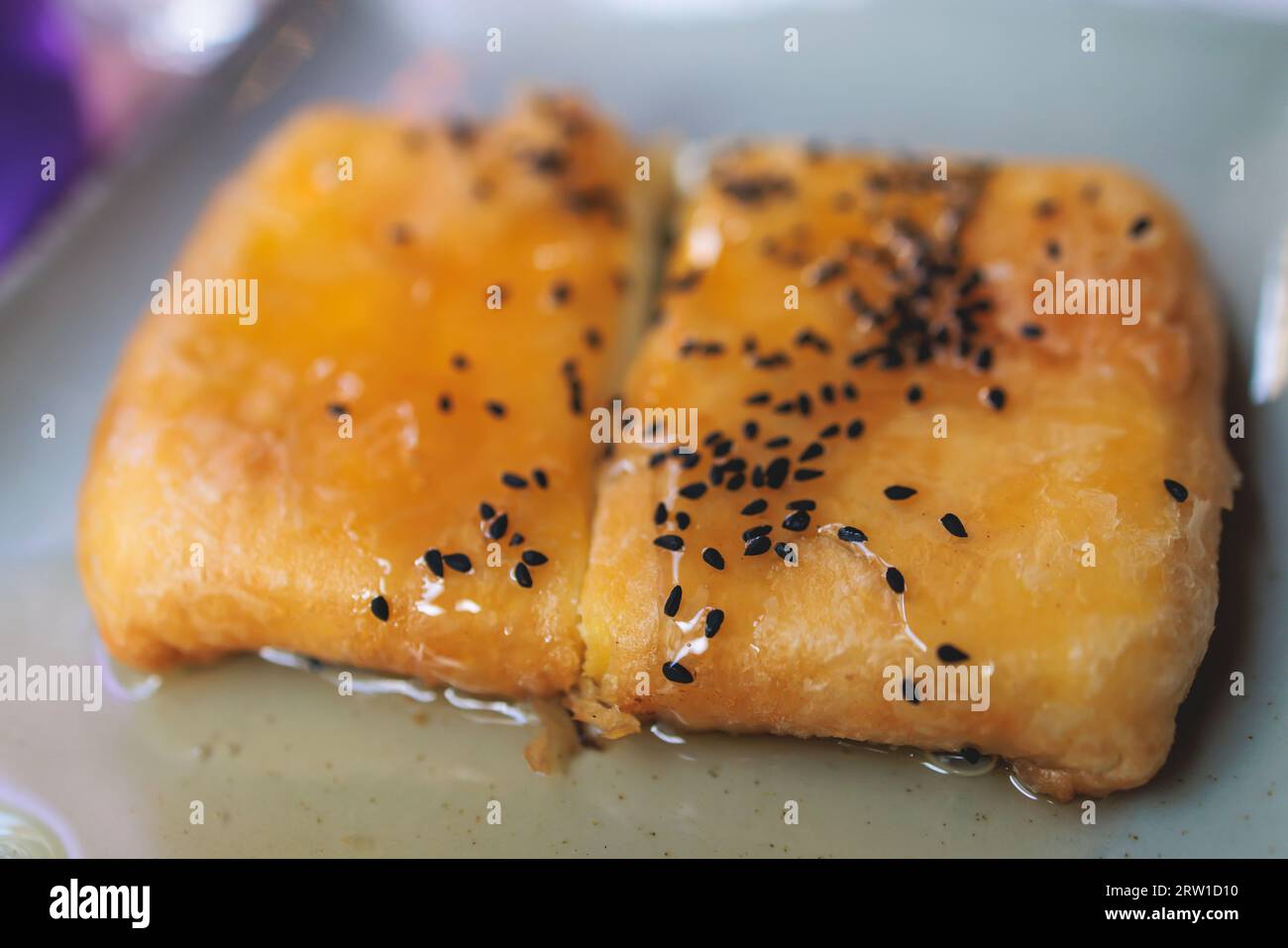 Fried feta cheese wrapped in phyllo pastry with honey and sesame ...