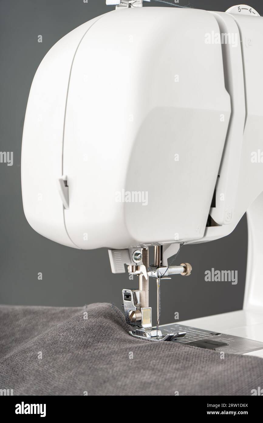 Modern sewing machine with gray fabric. Sewing process clothes ...