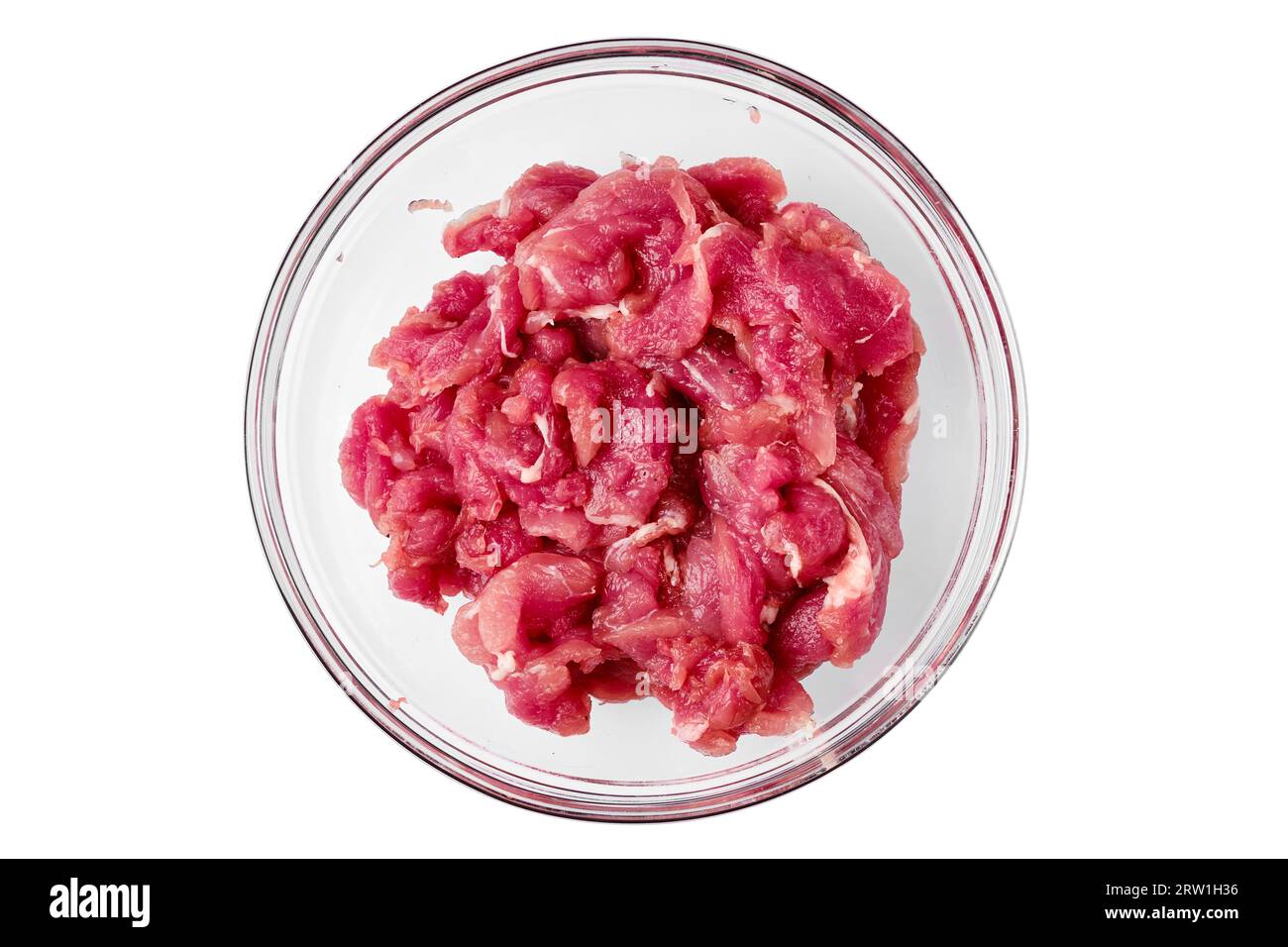 Top view of glass bowl with raw chopped pork tenderloin isolated on ...