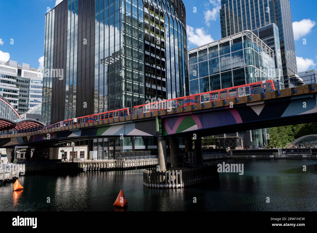 DLR train on elevated tracks crosses Middle Dock towards Canary Wharf ...