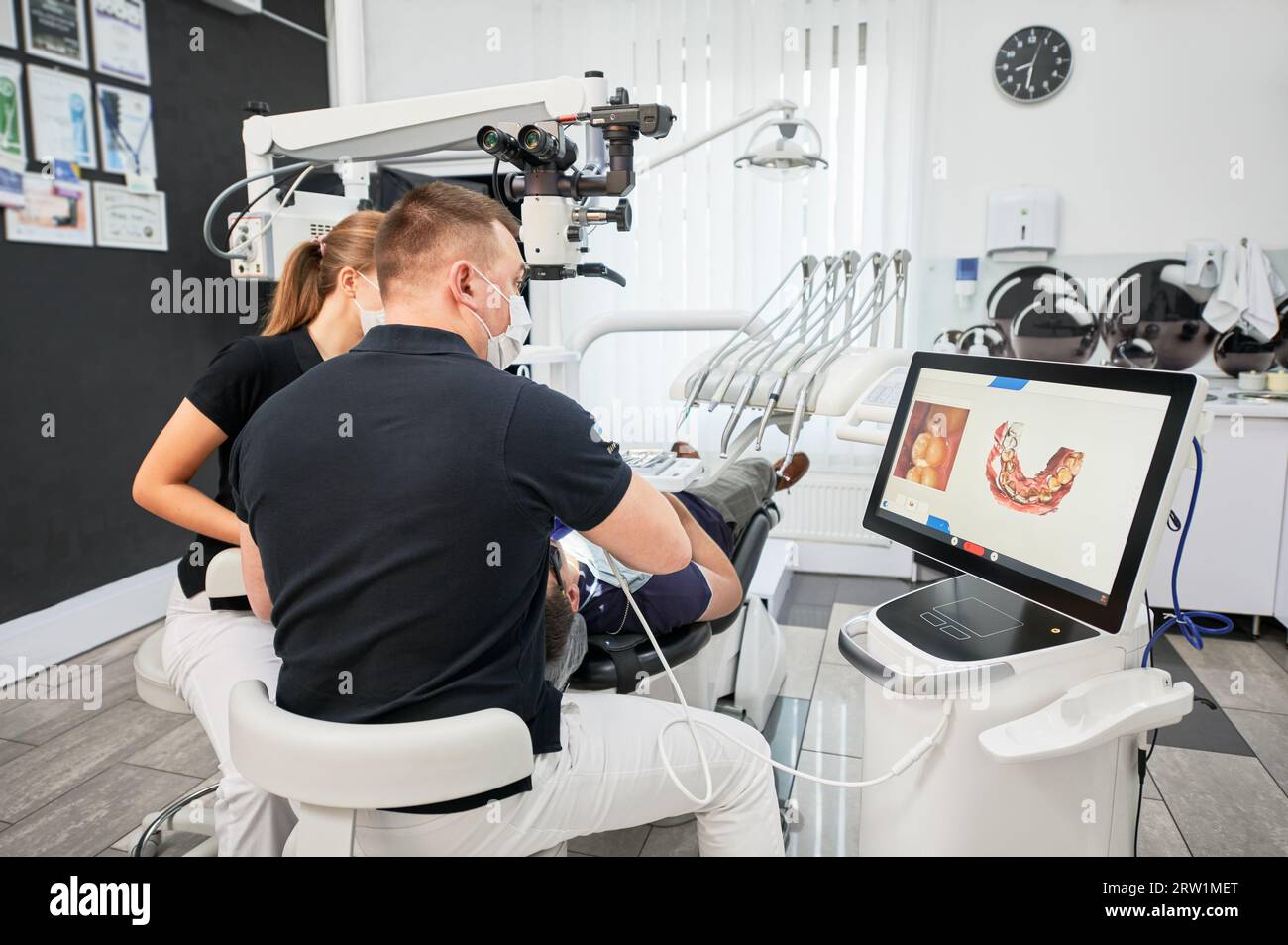 Dentist scanning patient's teeth with modern machine for intraoral ...