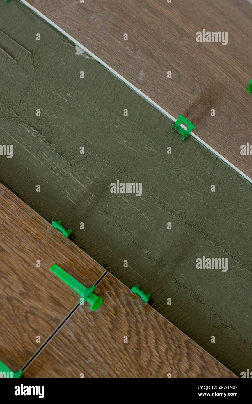 Tile levelling system, four plastic green clips with wedges. Close-up ...