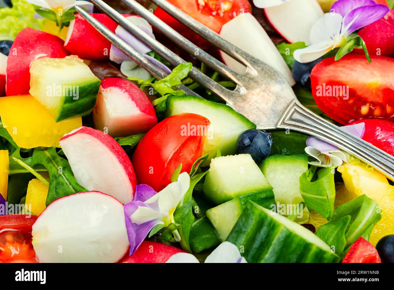 Bright vegetable salad with edible flowers,violets. Clean eating. Close ...