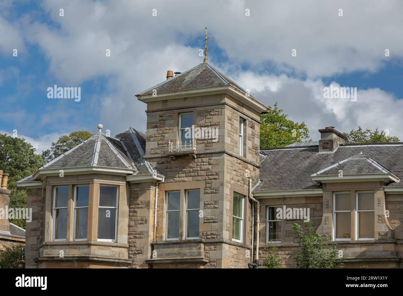 Square stone tower and roof tops of a building with many windows Stock ...