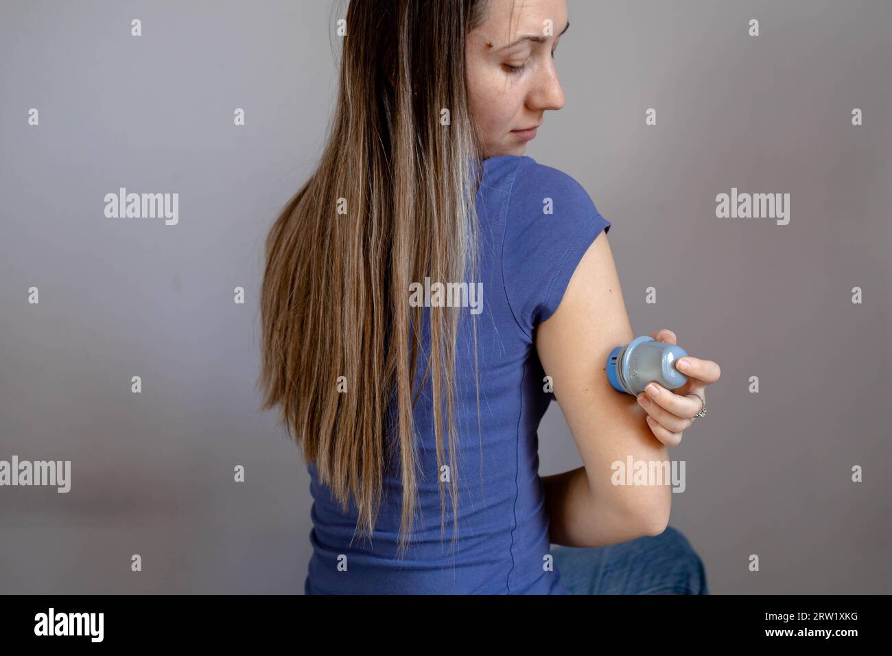 Girl applying flash glucose monitoring patch on her arm Stock Photo - Alamy