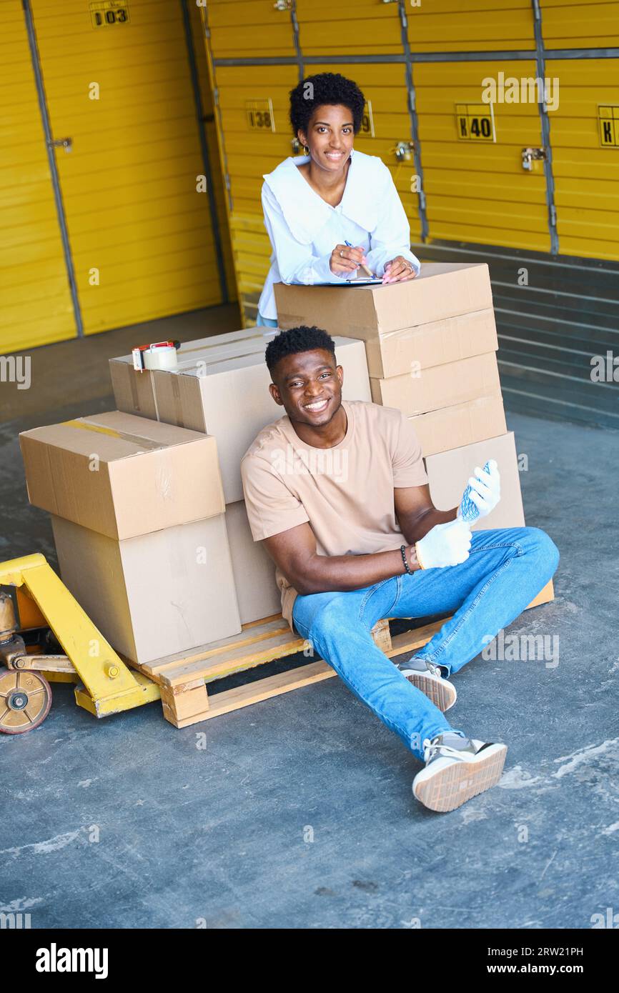 Warehouse employees, a female manager and male loader, at workplace ...