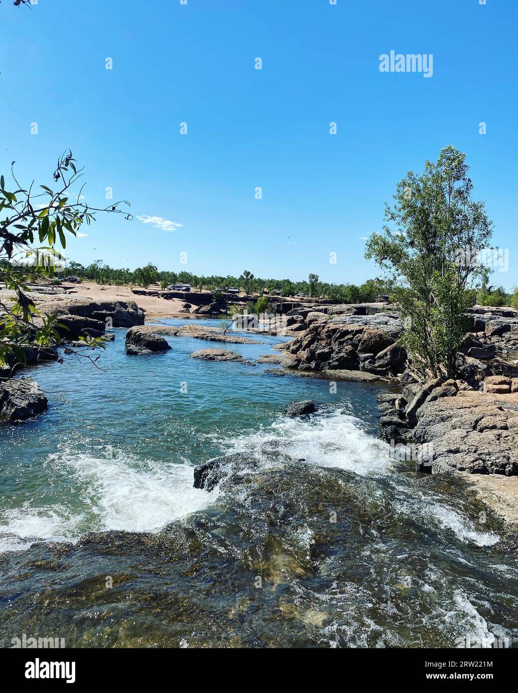 An aerial view of a river surrounded by lush greenery and large rocks ...