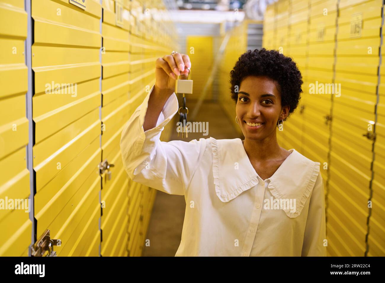 Charming African American woman holds a padlock with keys Stock Photo ...