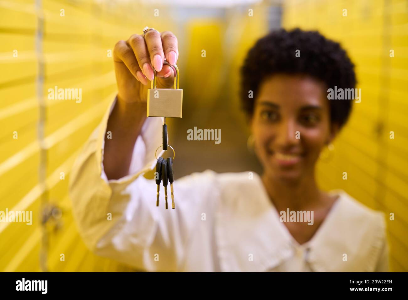 African American woman with neat manicure holds a padlock with keys ...