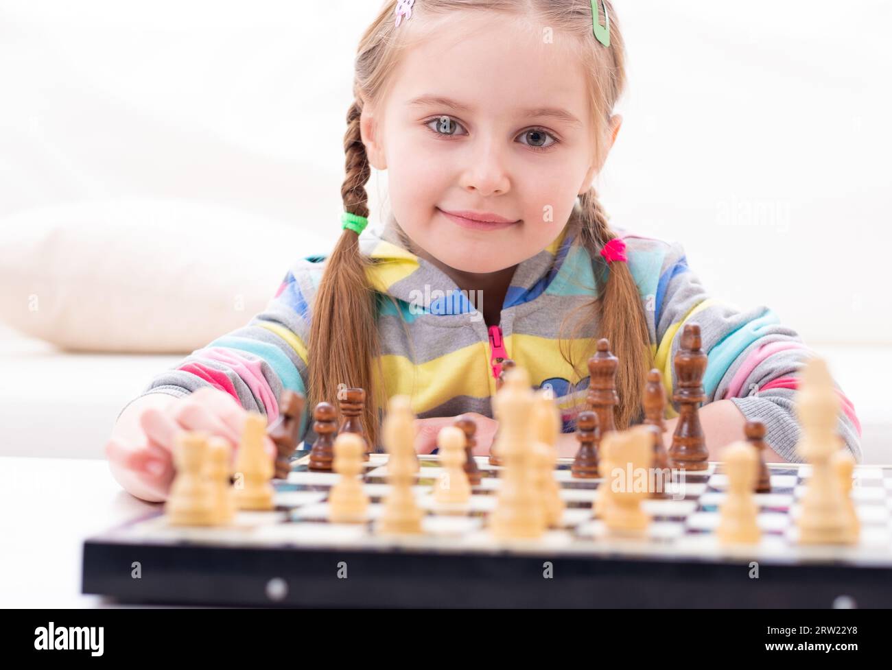 Cute little girl playing chess at home Stock Photo - Alamy