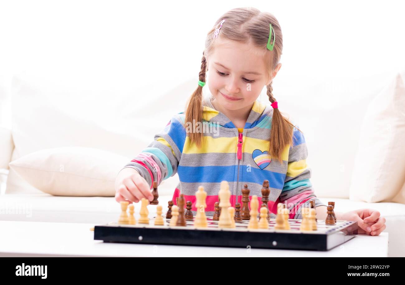 Cheerful smiling little girl is playing chess Stock Photo - Alamy