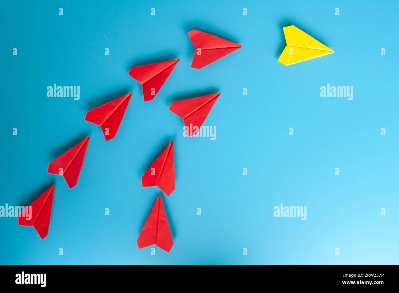 Top view of yellow paper airplane origami leading red paper airplanes ...