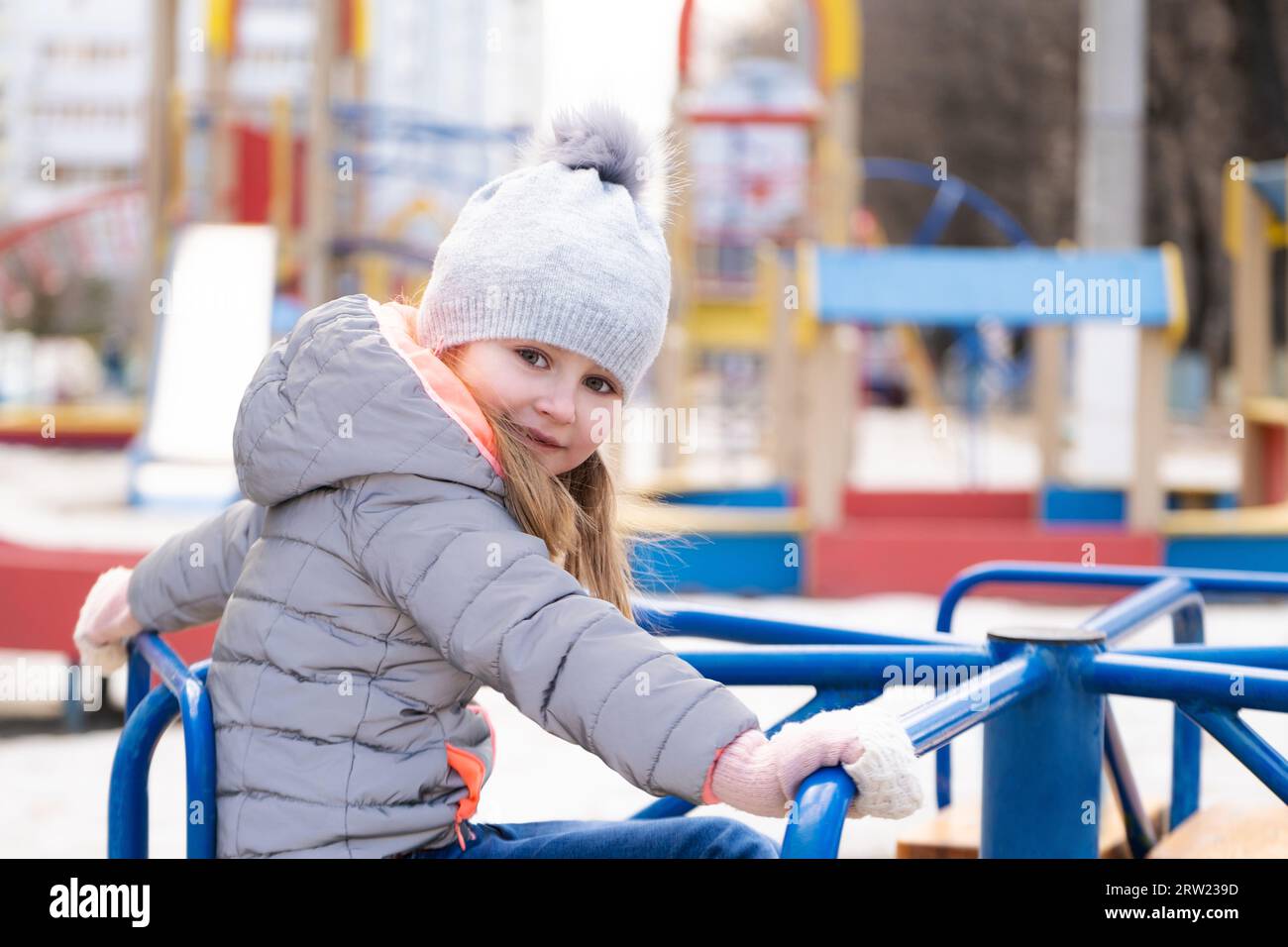 Happy child playing on rotating wheel toy at local playground at ...