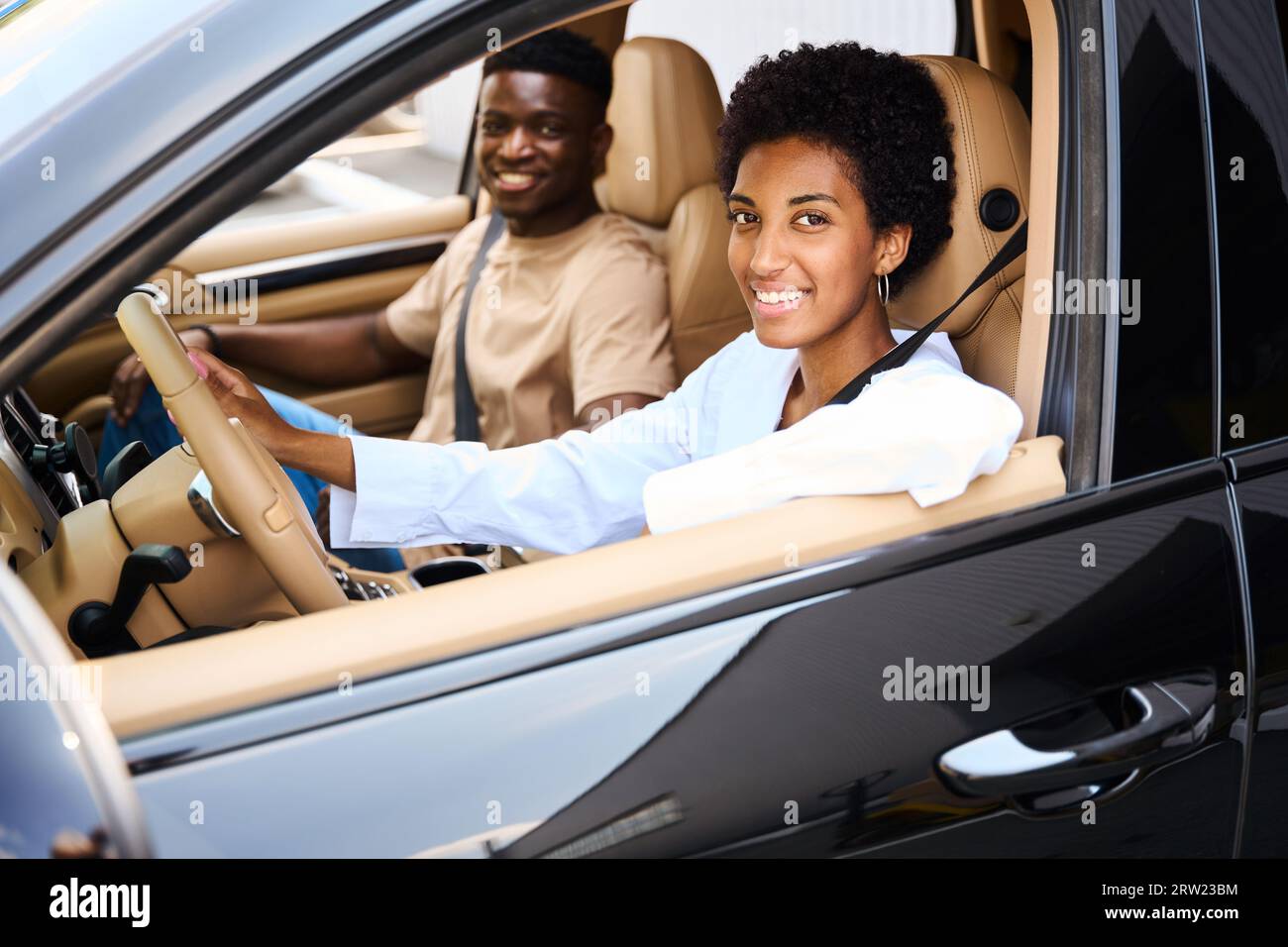 Smiling African American woman driving a car Stock Photo - Alamy