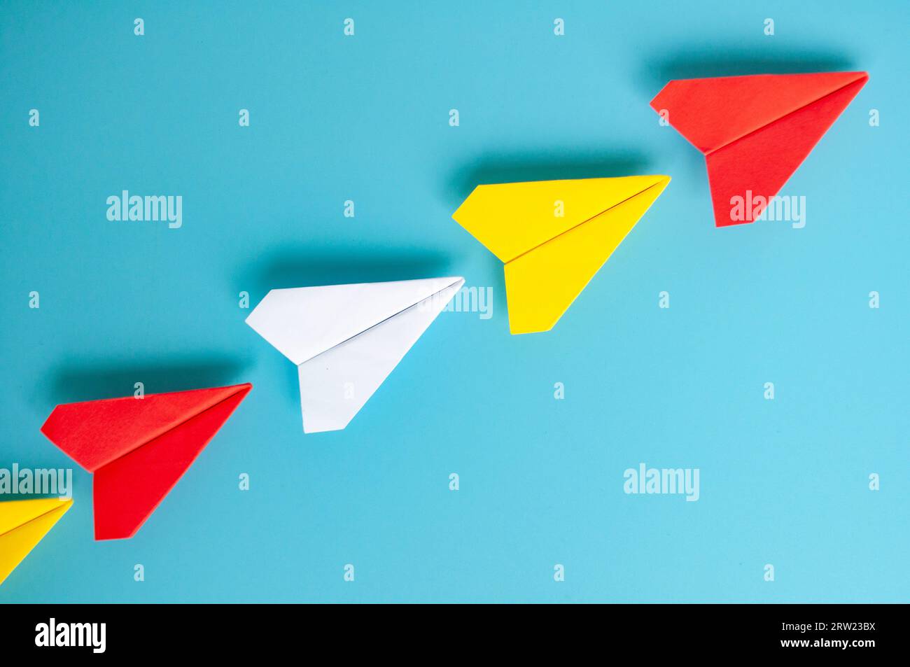 Top view of red paper airplane origami leading other paper airplanes ...