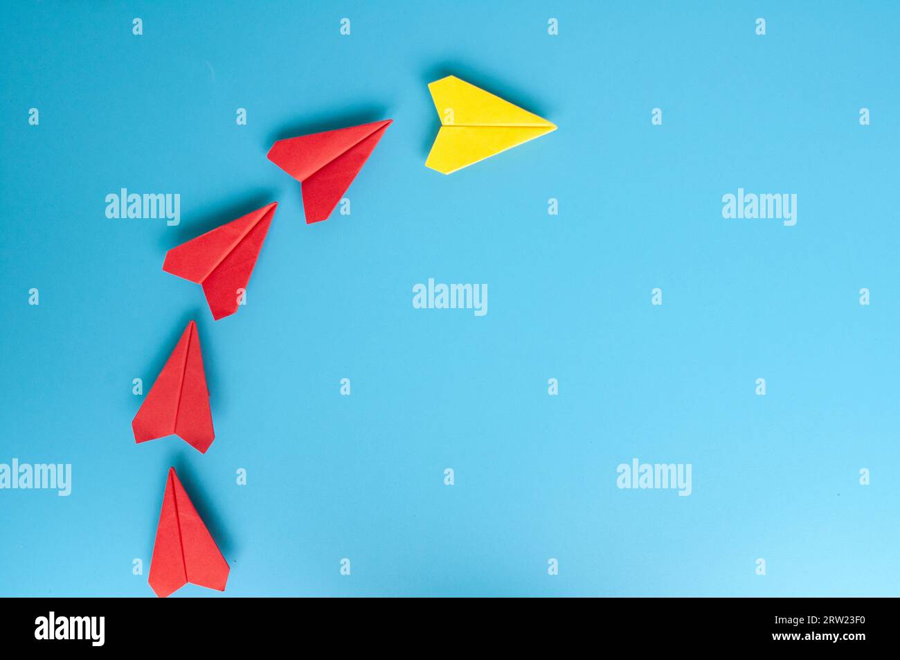 Top view of yellow paper plane origami leading red paper planes. With ...