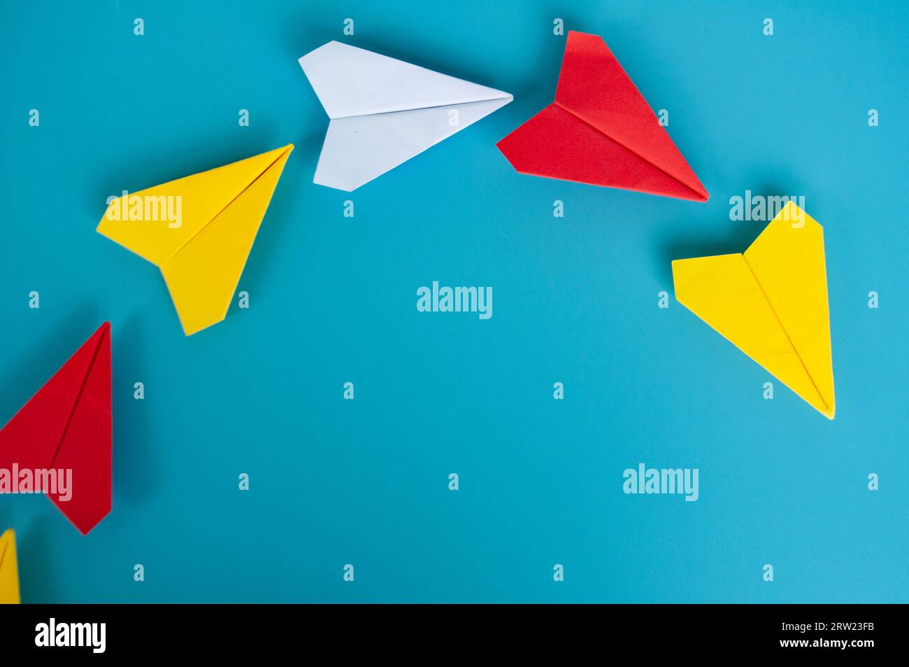 Top view of yellow paper airplane origami leading other paper airplanes ...